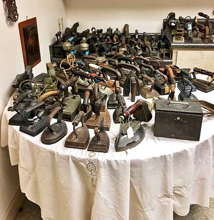 A collection of antique irons tells the evolution of domestic life, each representing hours of labor before permanent press and wrinkle-release fabrics.