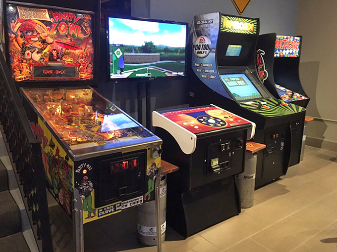 Colorful arcade machines create a wall of gaming history, each cabinet representing countless hours of quarters and determined button-mashing.