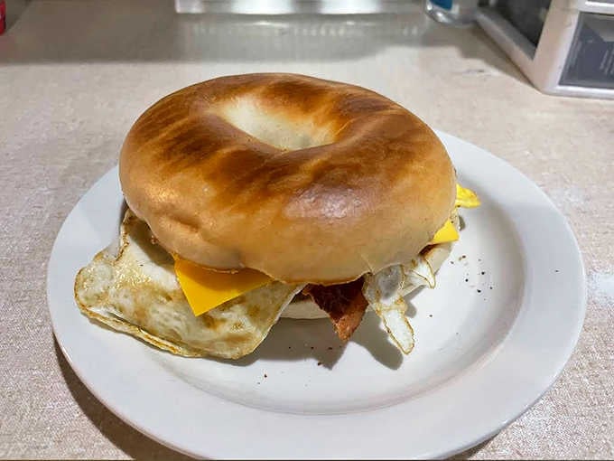 This isn't just breakfast &ndash; it's architecture! A perfectly toasted bagel supporting the weight of egg, cheese and bacon in harmonious balance.
