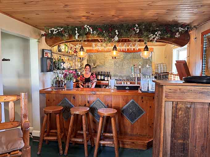 The cozy bar area with its wooden stools and carefully curated beverage selection is the perfect spot for a pre-dinner drink or post-meal nightcap.