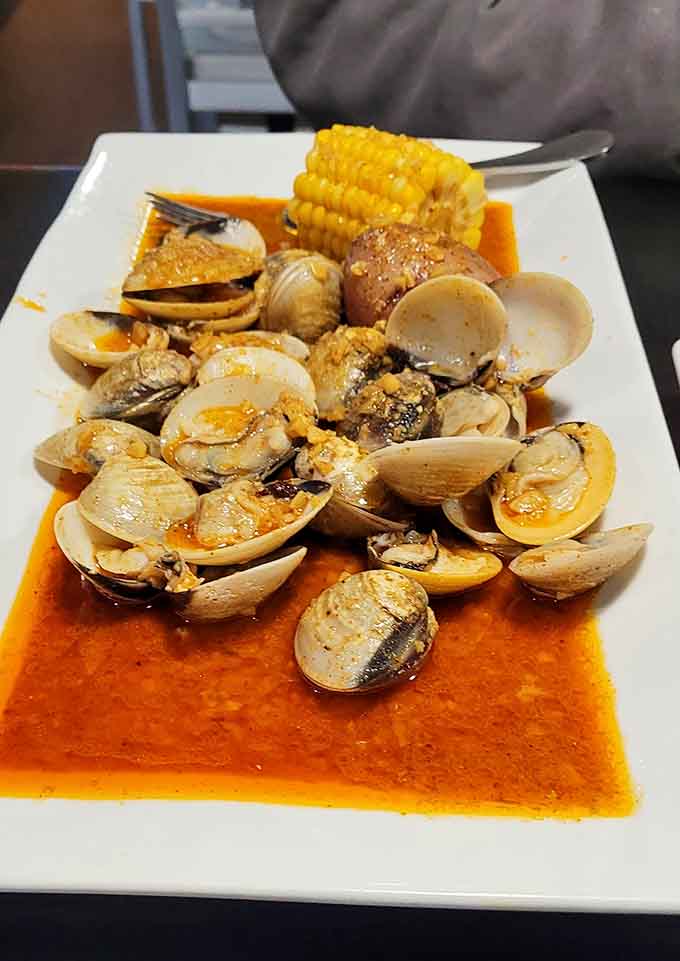 Baby clams swimming in flavorful broth, soaking up spices like tiny, delicious flavor sponges.