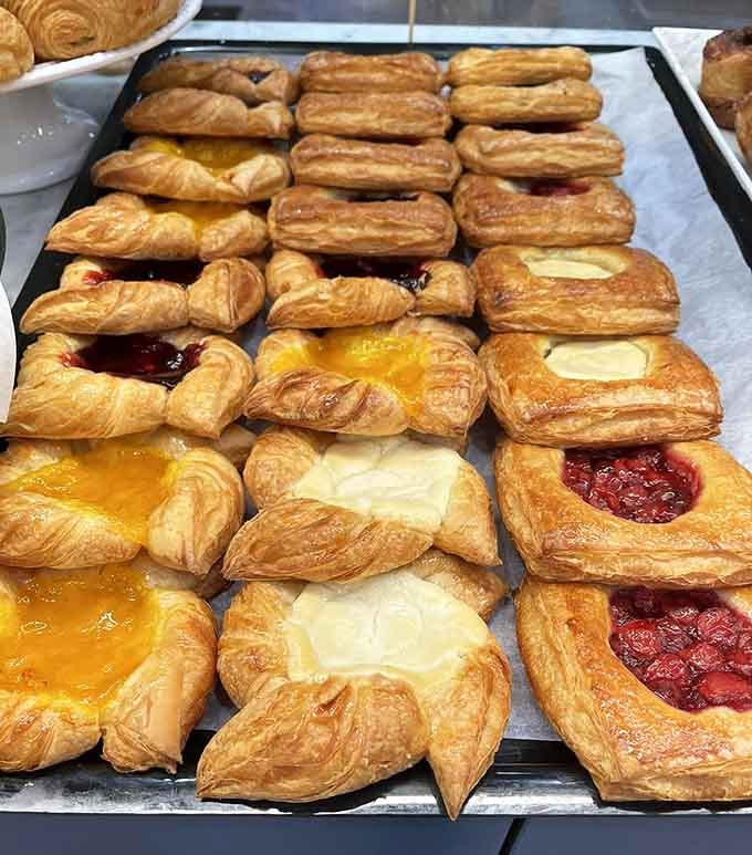 Danish pastries topped with fruit and cream cheese, looking like edible stained glass windows in the most delicious cathedral ever.