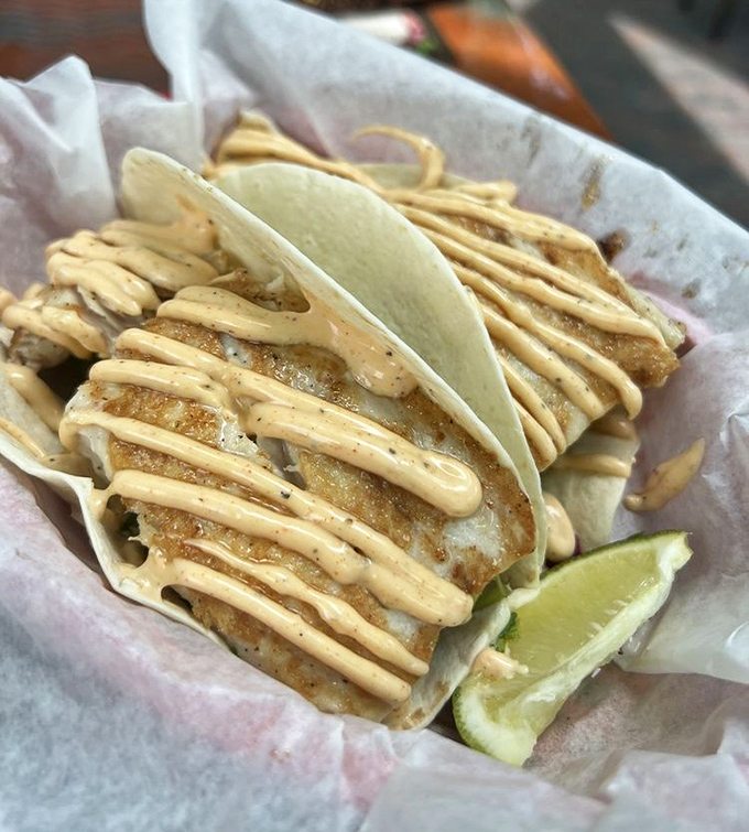 Cayo fish tacos: Crispy, flaky fish wrapped in warm tortillas and drizzled with sauce that captures the essence of Caribbean flavors in every bite.