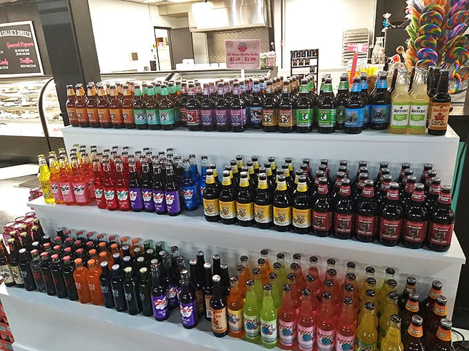 The craft soda collection spans three colorful shelves &ndash; a fizzy rainbow of flavors from classic root beers to exotic fruit concoctions.