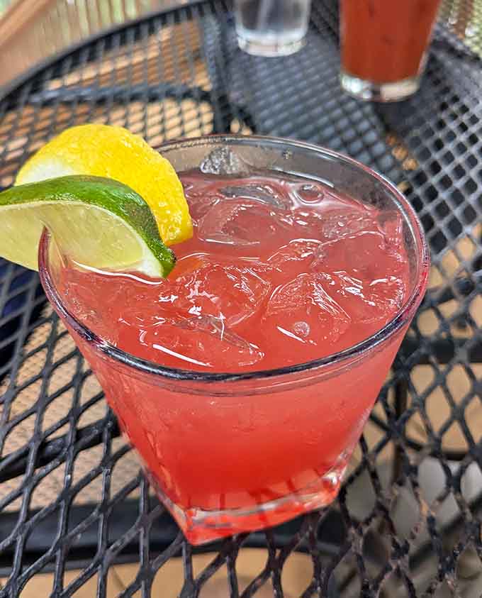 A vibrant cocktail with citrus garnish suggests the bar takes its drinks as seriously as the kitchen takes its food.