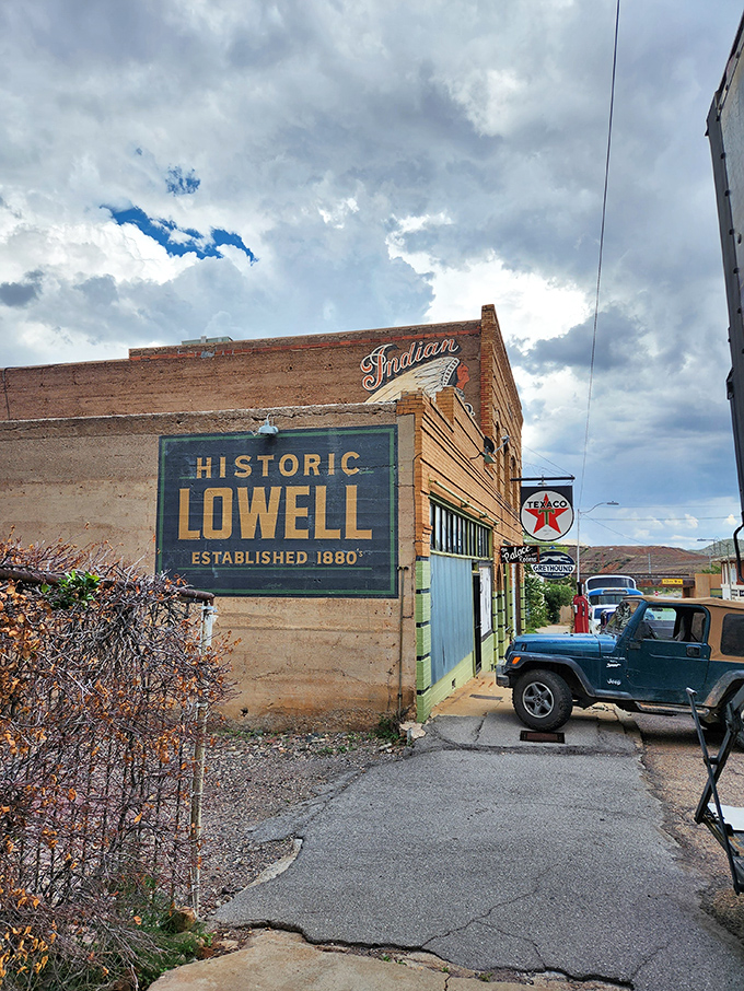 The "Historic Lowell" sign marks the entrance to Bisbee's most preserved district, complete with a vintage Texaco sign and classic vehicles.