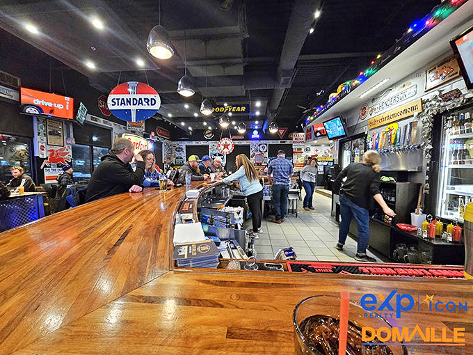 The bar gleams with promise, where cold brews flow beneath the watchful gaze of classic automotive logos and road signs of yesteryear.