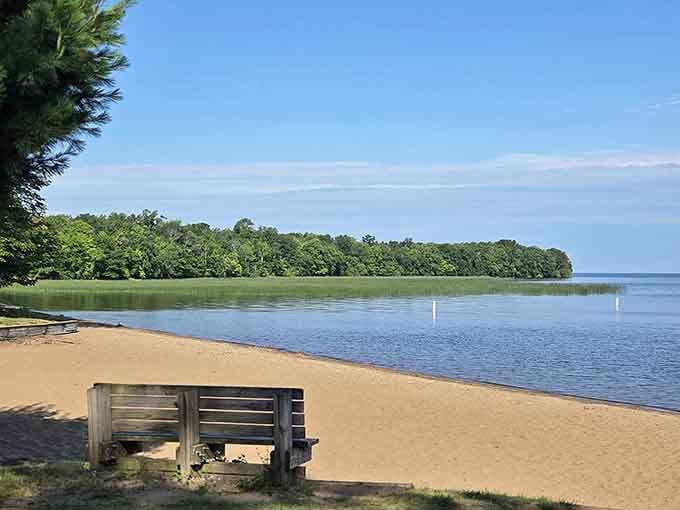 Find your perfect spot along the shoreline where a simple bench becomes the best seat in the house for nature's daily performance.