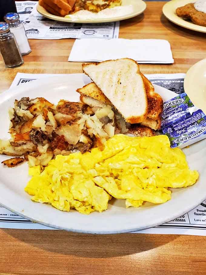 Breakfast trinity: golden home fries, fluffy scrambled eggs, and toast – the holy foundation of a perfect morning.