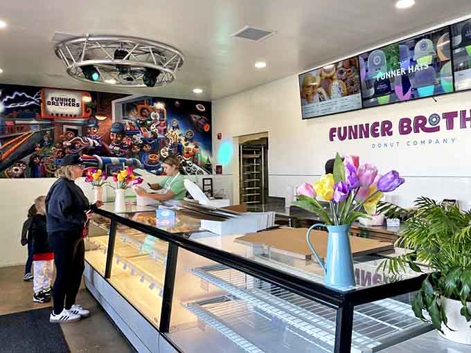 Fresh flowers and greenery add life to the modern, inviting space where donut dreams come true amid the gentle hum of morning conversations.