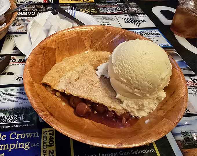 Berry pie with vanilla ice cream melting into warm fruit filling, the kind of dessert that inspires poetry.
