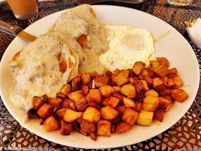 Biscuits and gravy done right&mdash;fluffy biscuits drowning in creamy sausage gravy alongside perfectly crispy home fries and sunny-side-up eggs.