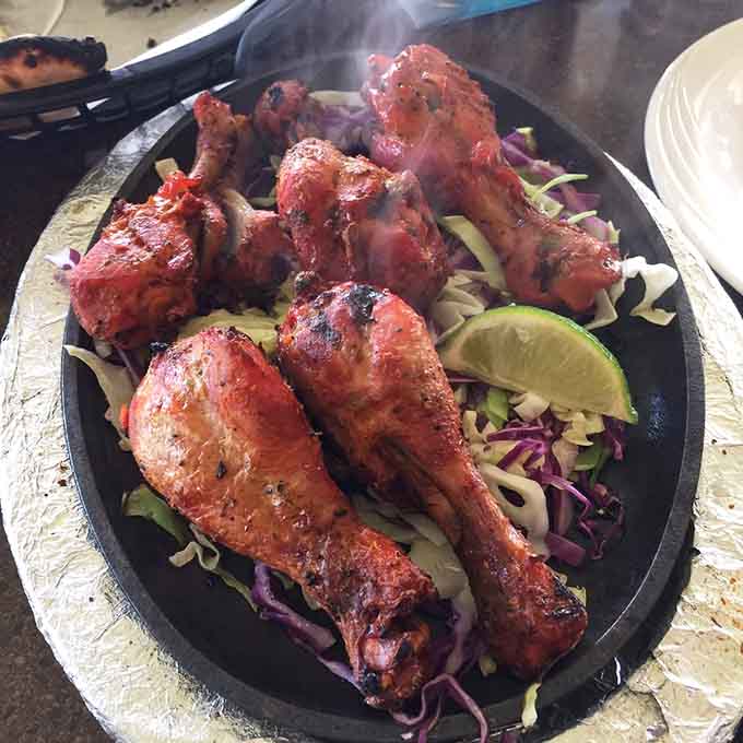 Tandoori chicken emerging from the clay oven with that distinctive char and smoky flavor that makes you understand why this cooking method has endured for centuries.