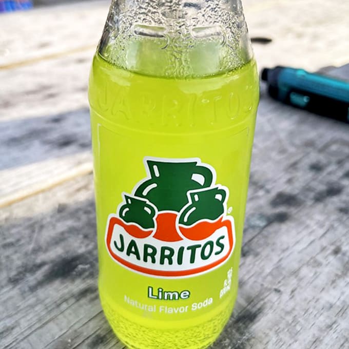 The electric green of Jarritos lime soda offers a refreshing, tangy counterpoint to the rich flavors of authentic Mexican cuisine.