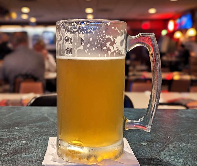 A frosty mug of beer catches the light, condensation beading on the glass &ndash; the perfect companion to Luigi's legendary pizza.