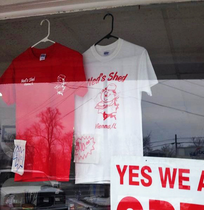 Ned's Shed t-shirts hanging in the window &ndash; the ultimate souvenir that says "Yes, I've experienced burger nirvana in Vienna, Illinois."