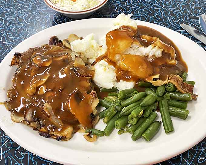 Homestyle meatloaf swimming in rich gravy alongside green beans that still have some snap &ndash; a plate that whispers "someone's grandmother is in the kitchen."