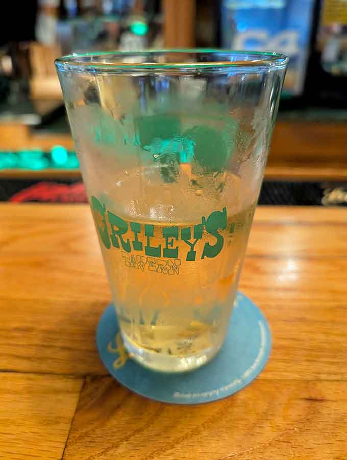 An ice-cold beverage in an O'Riley's glass, condensation beading down the sides like liquid happiness.