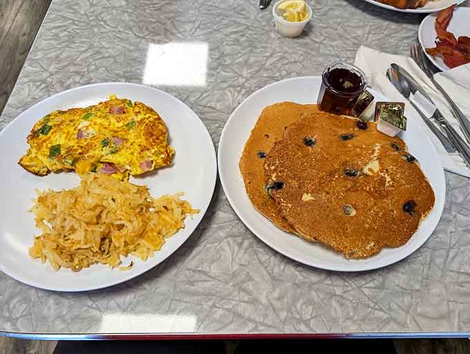 The perfect breakfast duet &ndash; a fluffy omelet singing harmony with a blueberry pancake that's wider than your plate.