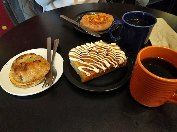 The morning trifecta: a savory bialy, sweet cinnamon roll, and Georgian cheese bread &ndash; proof that breakfast indecision can lead to delicious solutions.