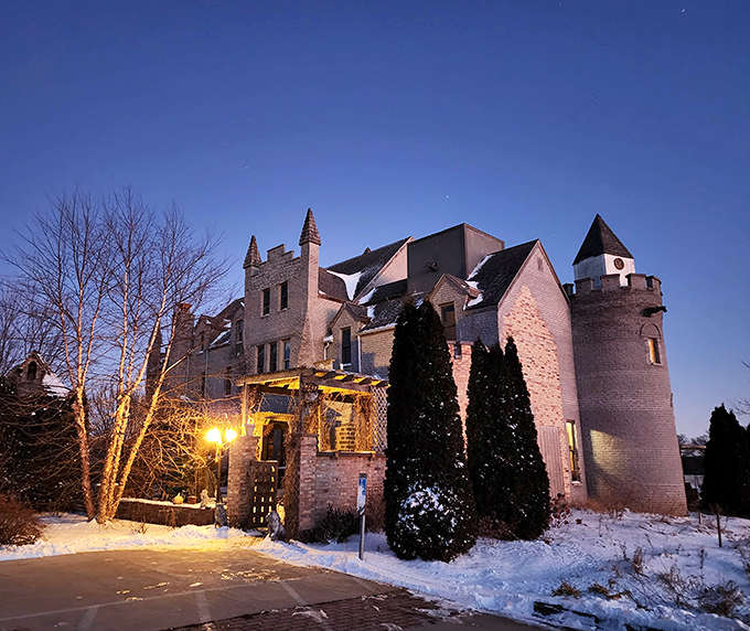 Winter transforms Ravenstone into a snow-dusted fairy tale, the illuminated castle glowing warmly against the cold night sky.