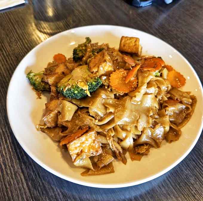 Wide rice noodles dancing with vegetables and protein in a savory sauce&mdash;comfort food that speaks the universal language of "mmmmm."