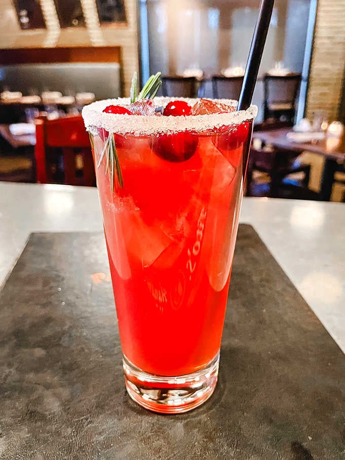 This vibrant cocktail doesn't just quench thirst &ndash; it announces its presence with cranberry brightness and rosemary sophistication.