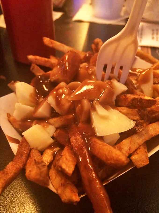 Poutine done right means fries drowning in gravy and cheese, creating the kind of mess that's absolutely worth making.