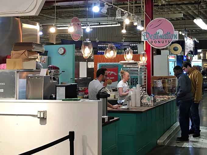 Behind the counter, culinary artists transform simple ingredients into circular masterpieces while customers watch in sweet anticipation.
