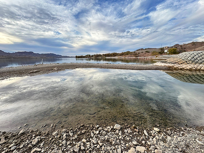 Mirror-like waters reflect clouds in perfect symmetry, doubling the beauty in this unexpected desert paradise.