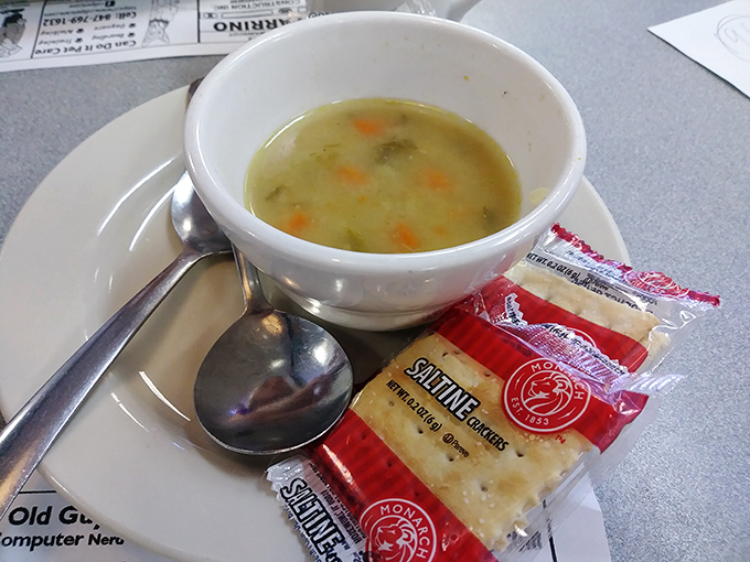 A bowl of homemade soup that warms the soul, accompanied by crackers that are more than just an afterthought.