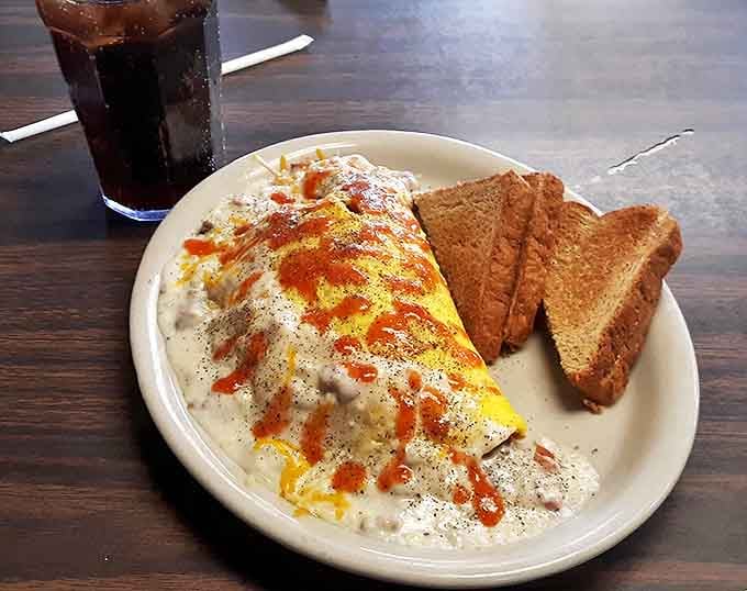 Southern Country Omelet: A golden envelope of eggs stuffed with savory fillings and smothered in country gravy &ndash; breakfast doesn't get more satisfying than this.