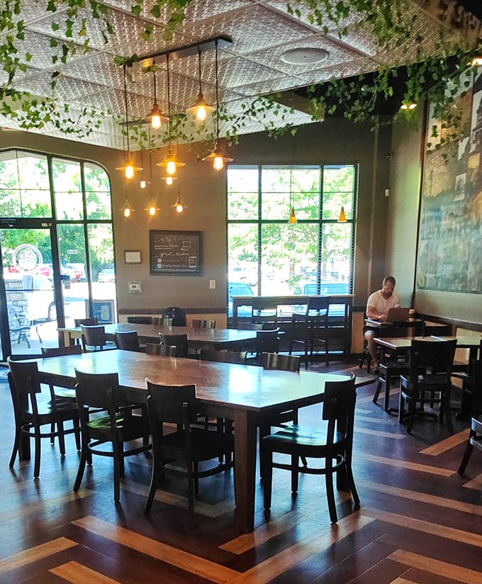 Multiple seating areas with natural light and hanging plants create an atmosphere that says "stay awhile" without being pushy about it.