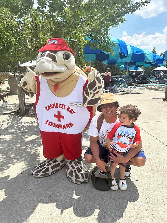 Zoombezi Bay's turtle mascot, decked out in lifeguard gear, poses with visitors who are momentarily distracted from their water adventures.