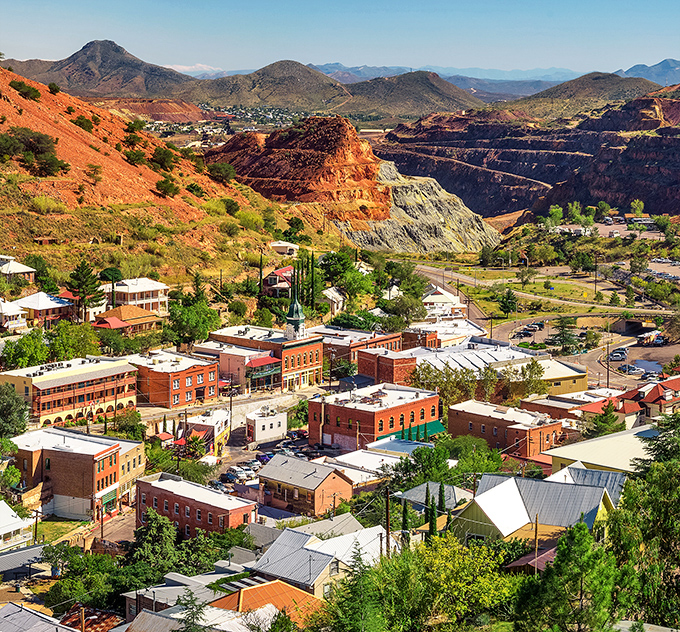 Bisbee unfolds dramatically against the Mule Mountains, its colorful buildings nestled into hillsides surrounding the massive open-pit mine.