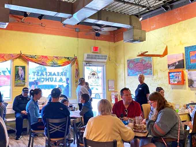 Happy diners fill the sunny space, creating that perfect buzz of conversation and laughter that makes a restaurant feel alive with possibility.