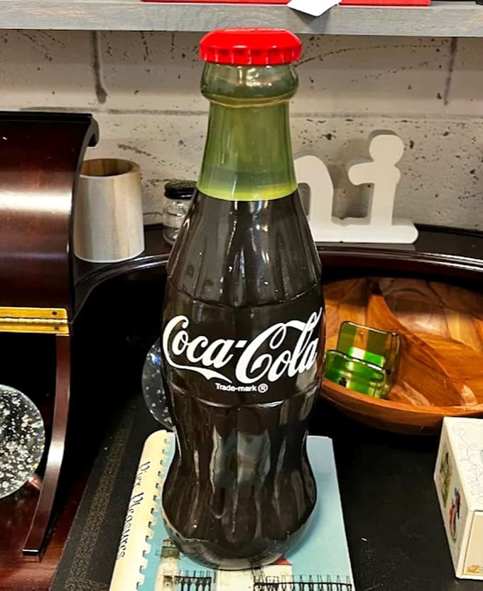 That vintage Coca-Cola bottle isn't just a beverage container; it's a portal to summer afternoons and simpler times.