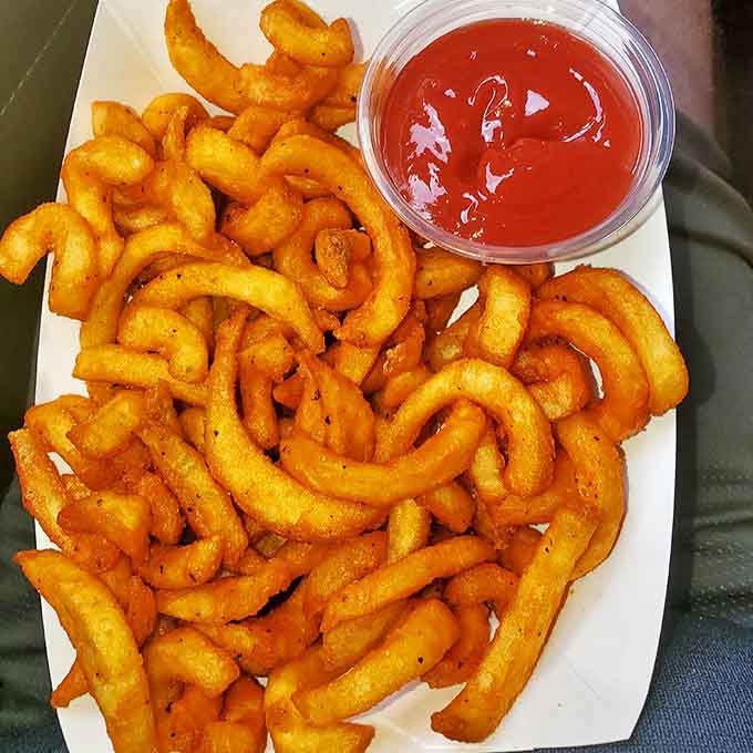 Curly fries &ndash; because straight fries are just too predictable &ndash; served with a side of ketchup for necessary dipping operations.