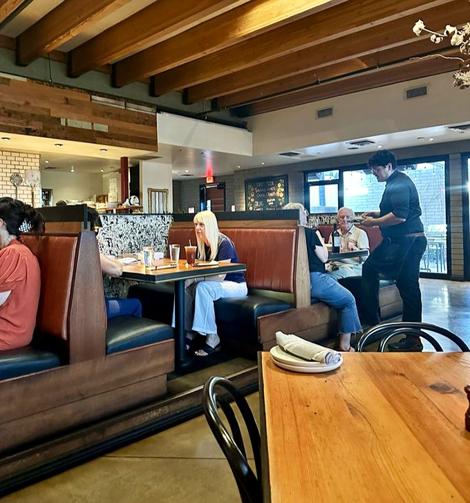 Leather booths cradle conversations while attentive servers orchestrate the dining experience with the precision of a well-rehearsed symphony.