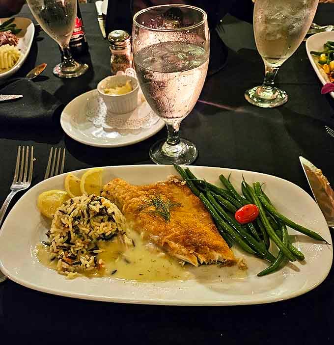 This delicate white fish fillet rests on a bed of wild rice, surrounded by vibrant green beans &ndash; proof that not all prison sentences involve heavy food.