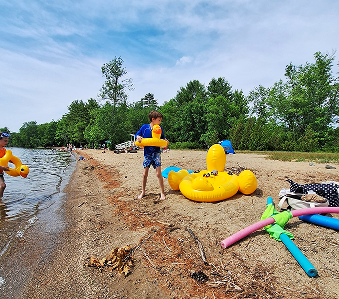 Beach toys scattered like colorful confetti &ndash; evidence of childhood joy in progress at the lake's edge.