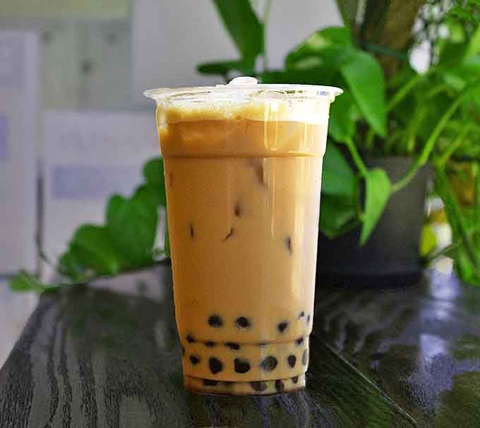The Thai milk tea with boba pearls provides a refreshing counterpoint to sweet treats, its amber liquid hiding chewy tapioca treasures.
