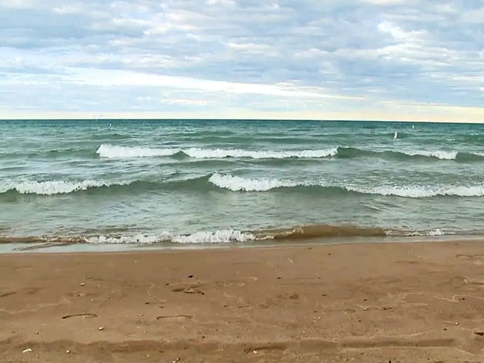 Racine North Beach stretches as far as the eye can see, with pristine sand meeting the endless blue of the sea.