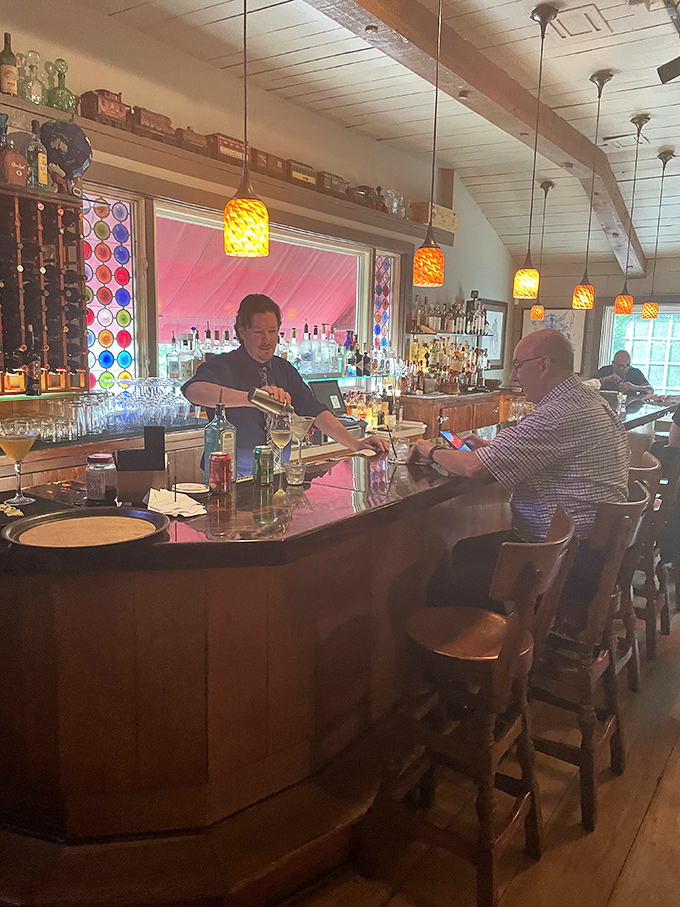 The bar at Sebastian's isn't just a waiting area – it's a destination itself, with colorful pendant lights creating a warm, inviting atmosphere.