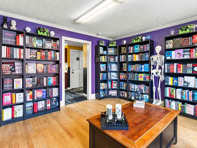 Purple walls and skeleton companions create a space where the macabre meets the literary in perfect spooky harmony.