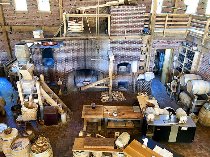 The historic kitchen's brick hearth and hanging cookware reveal the labor-intensive reality of meal preparation before microwaves made dinner a one-minute affair.