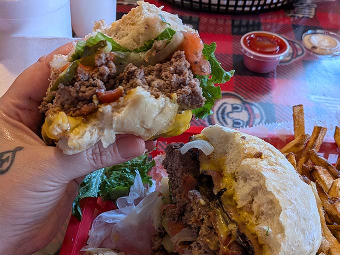 A perfectly constructed burger reveals layers of fresh toppings and melted cheese – architecture you can eat.