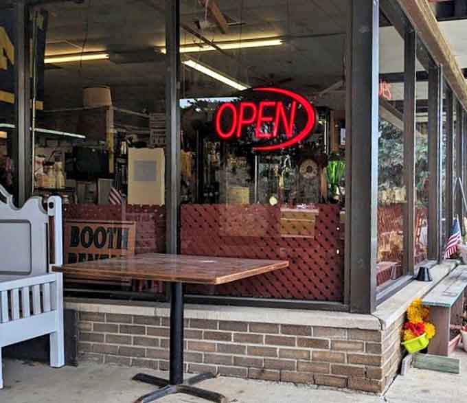 The glowing "OPEN" sign beckons like a lighthouse guiding treasure hunters safely to shore, promising adventures in every aisle inside.