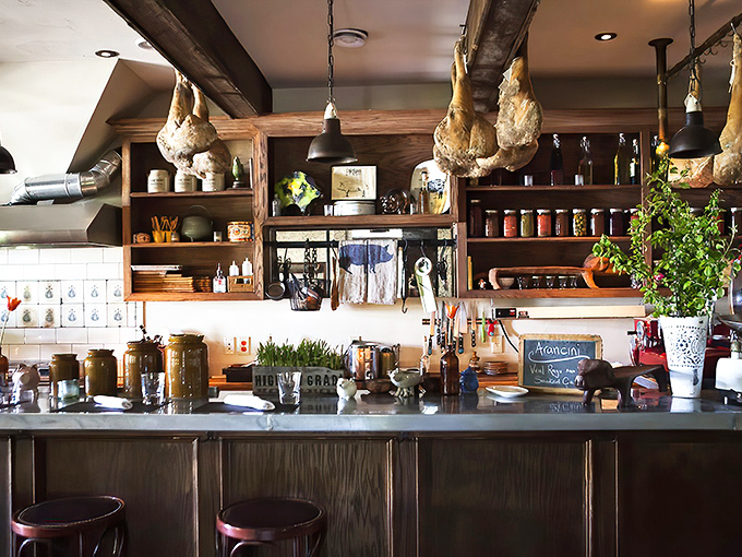 Behind the counter, hanging herbs and preserved ingredients hint at the kitchen's commitment to using everything the farm produces.
