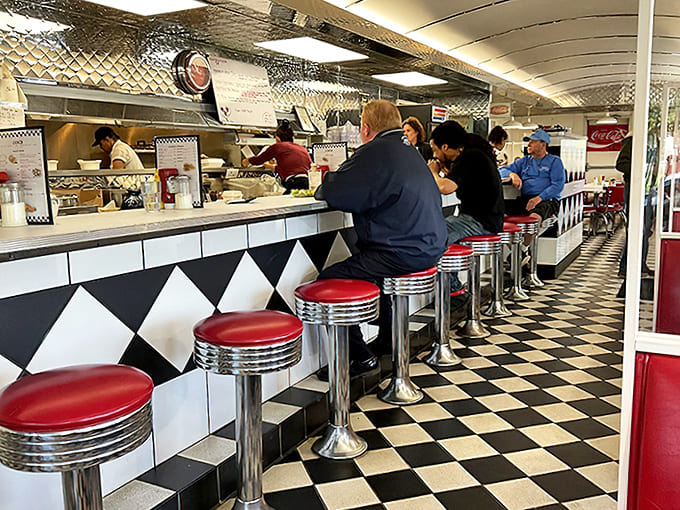 The counter seats offer front-row views of the culinary action, where regulars perch on chrome stools for their morning ritual of coffee and conversation.